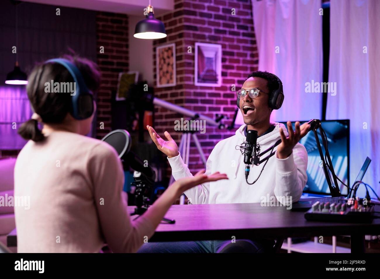 Podcast presenter recording livestream chat at production station ...