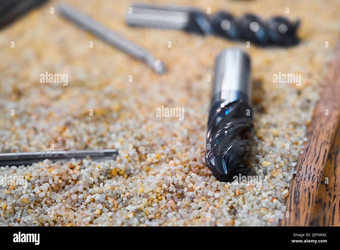 Set of various new drills on sand in container close view Stock Photo ...