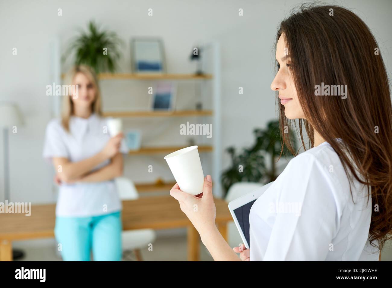 Great time at lunch. Two friendly colleagues interns in white uniform ...