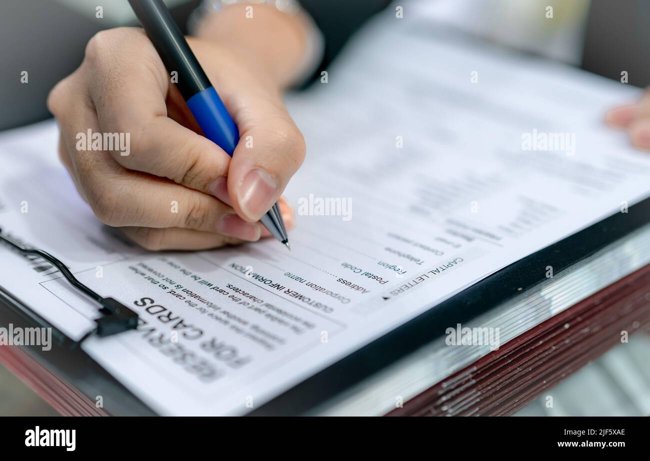 Business people hand holding pen and fill corporation profile in paper ...