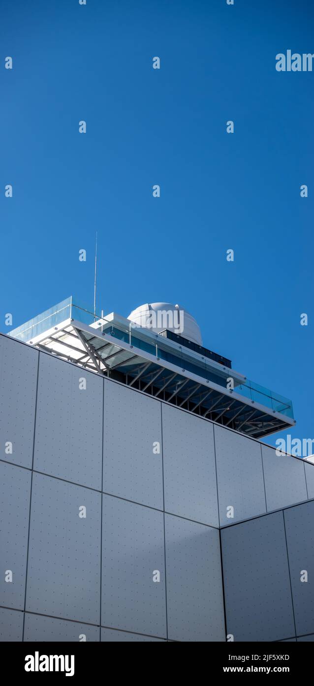 Details of a white modern public building. Sky observation tower on top ...
