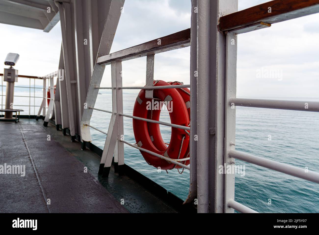 Lifebuoys hang on board a sea ferry floating on the waves Stock Photo ...