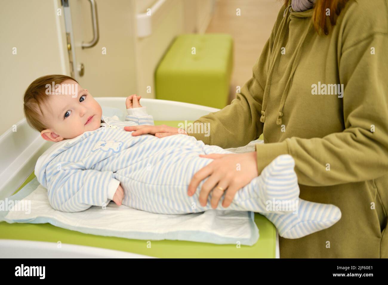 Mom with a child in the corridor of the hospital on the table for ...