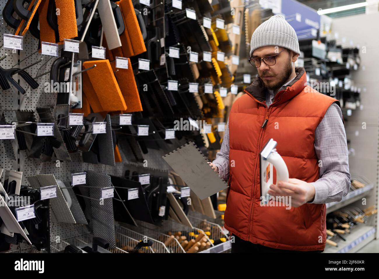 the buyer chooses a putty tool in his home Stock Photo - Alamy