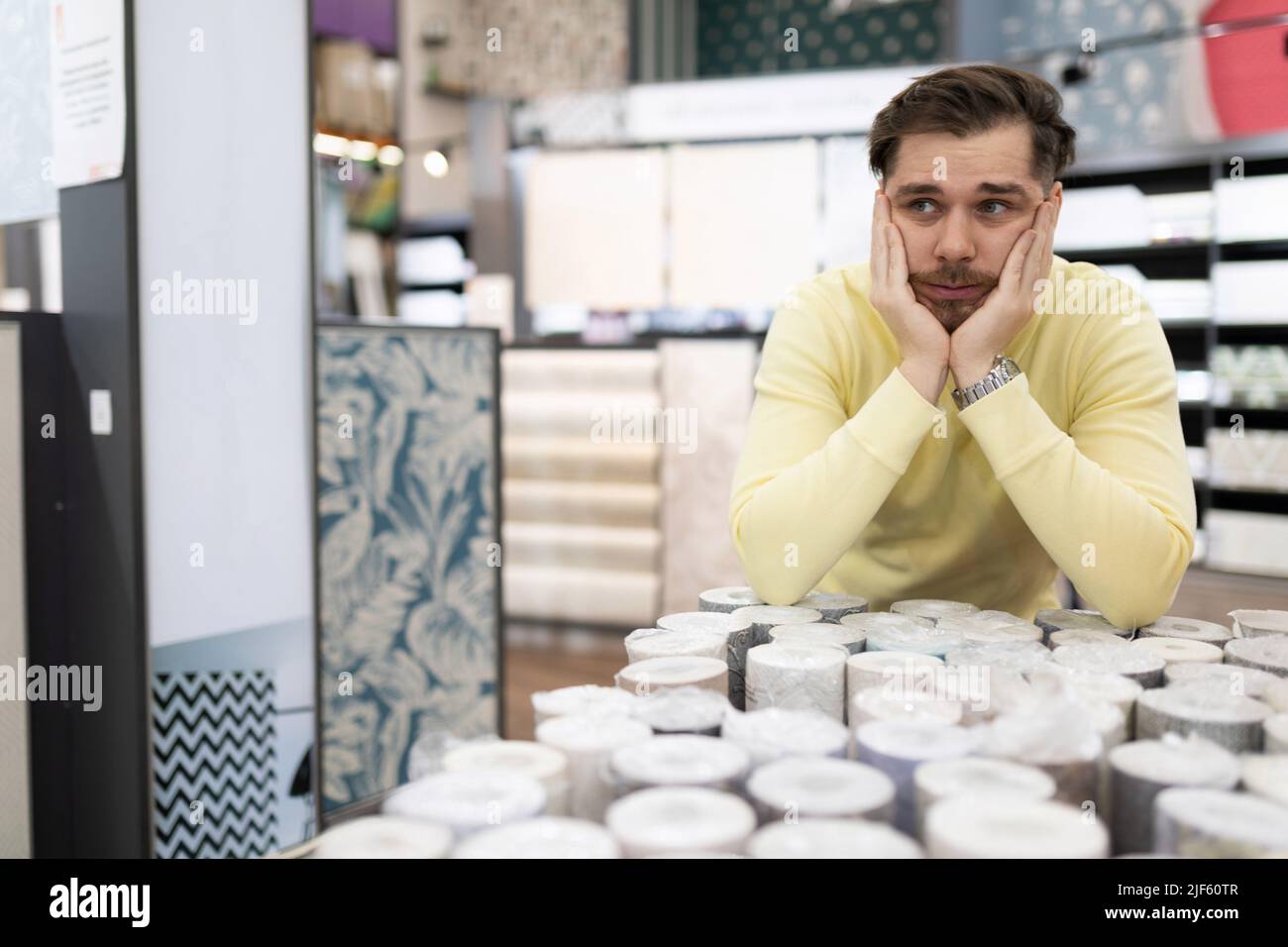 confused customer in a paper wallpaper store Stock Photo - Alamy