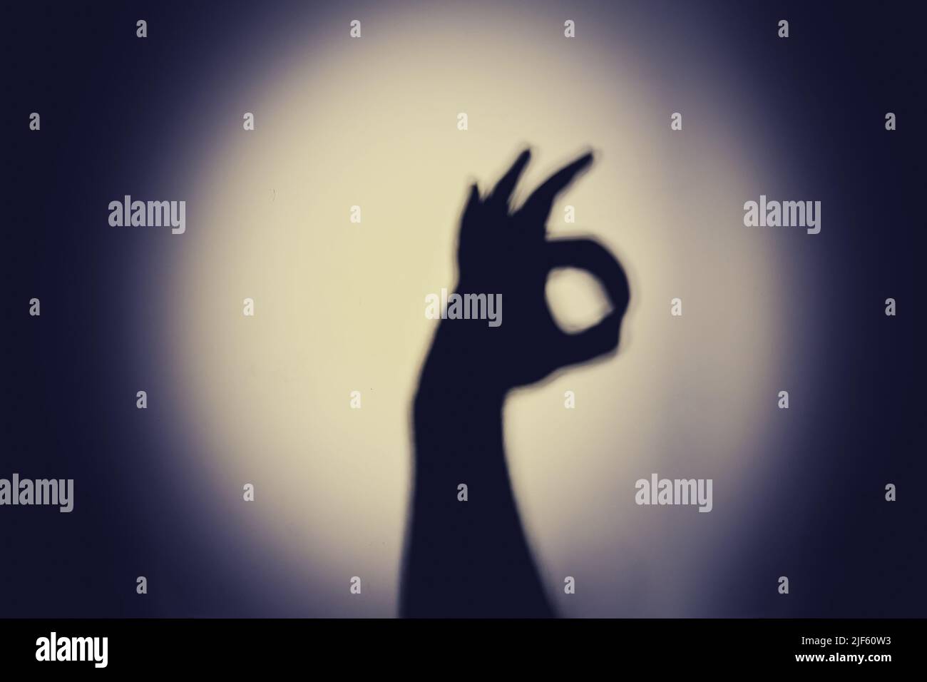 Shadow of a hand from the night light of a flashlight on a white wall ...