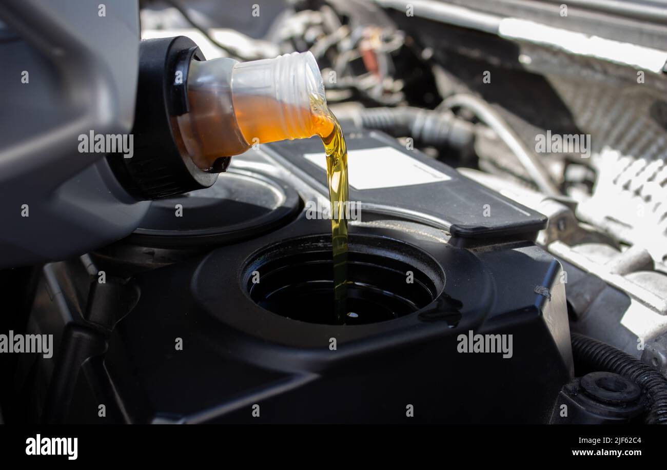 Refueling and pouring oil quality into the engine motor car ...
