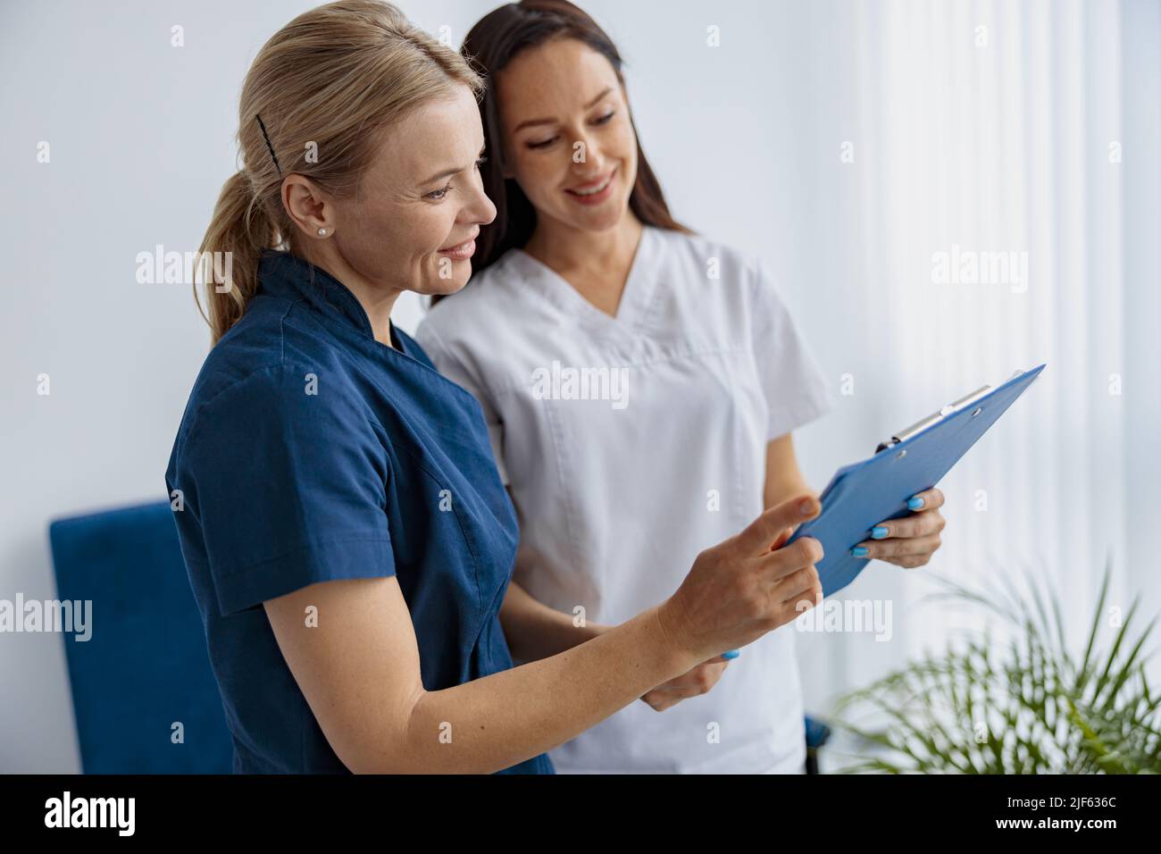 Doctor and nurse solve work issues standing in modern clinic hall Stock ...