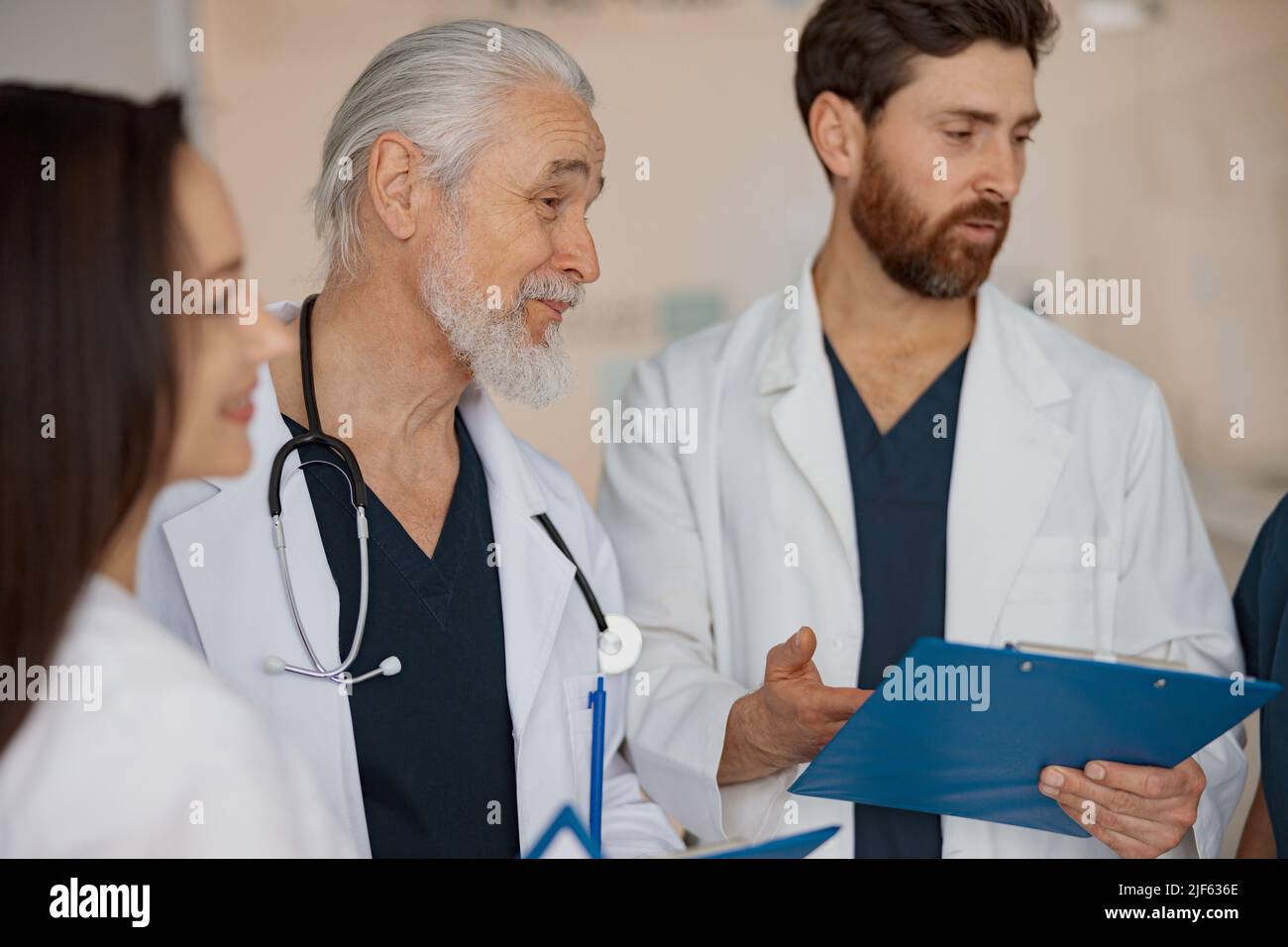 Group of doctor colleagues discussing patient diagnosis stand in clinic ...