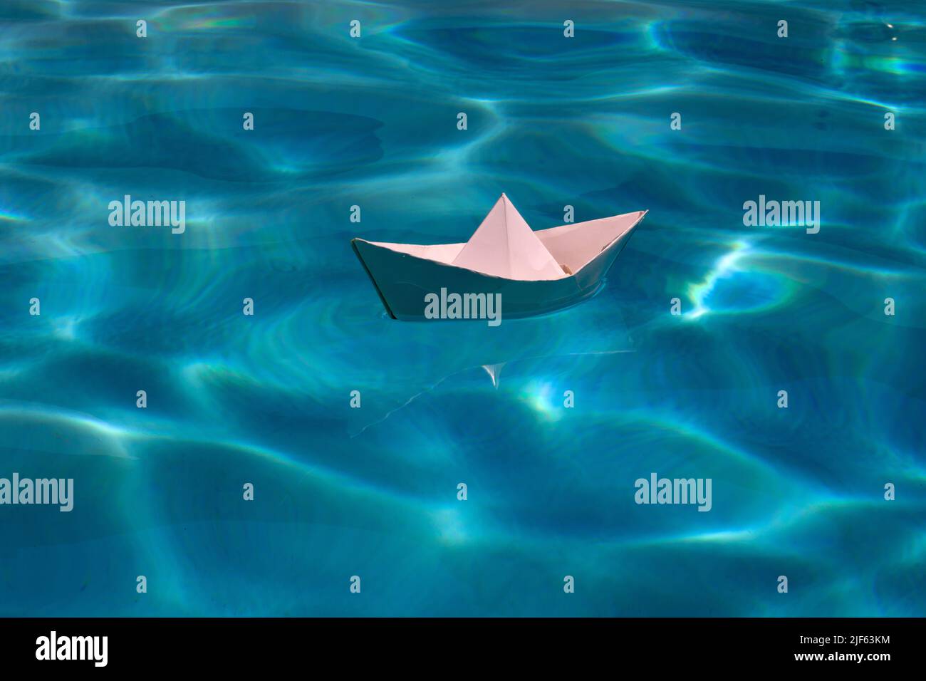 Paper boat sailing on blue water surface. Paper ship sail. Paper boat ...