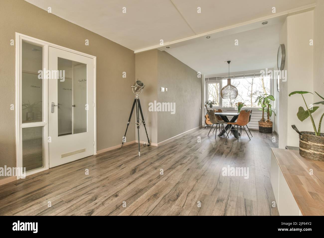 Simple interior of light living room with gray sofa in front of TV and ...