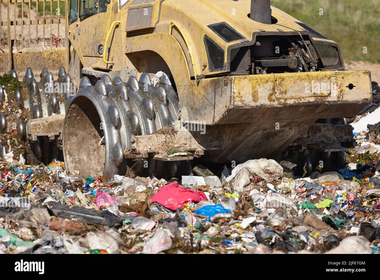 Heavy machinery shredding garbage in an open air landfill. Waste Stock ...