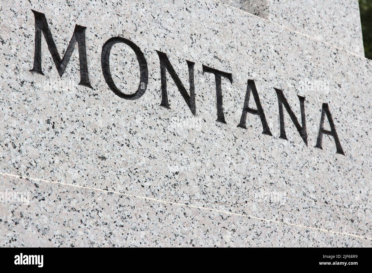 Montana - US state name engraved in grey granite stone Stock Photo - Alamy