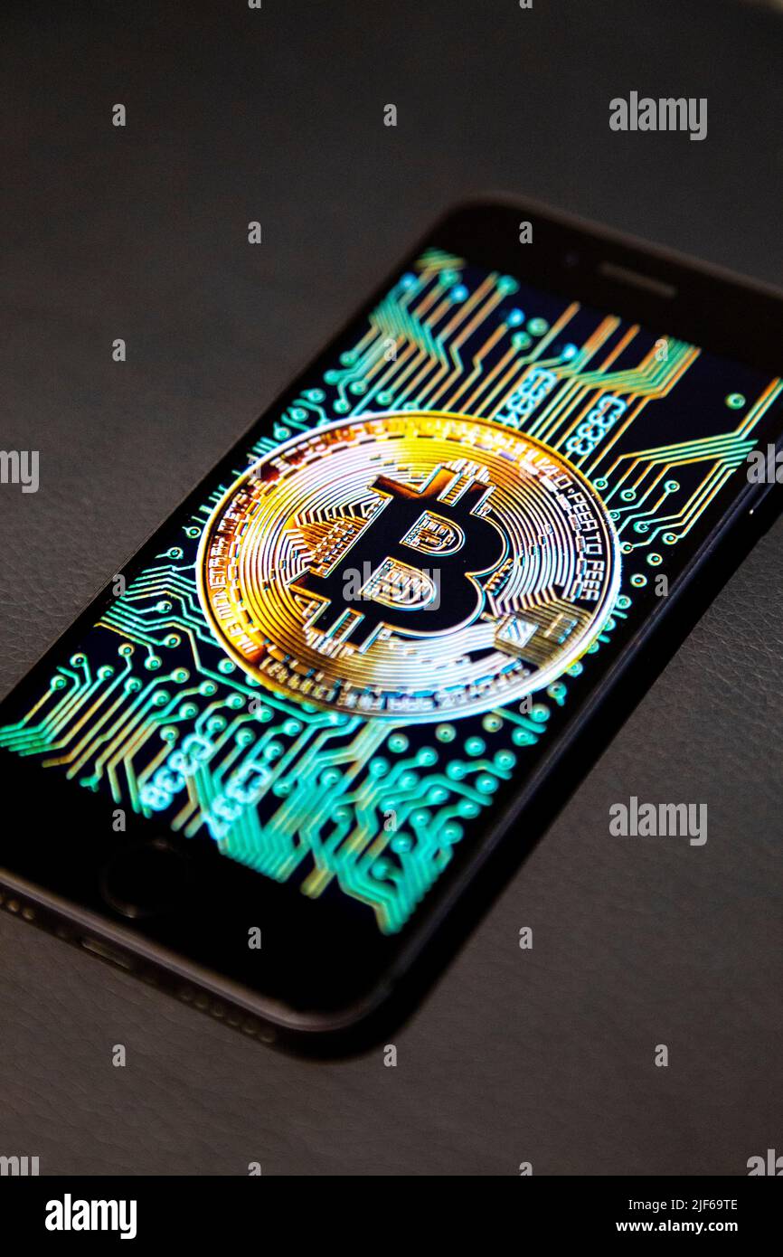 Bitcoin logo on a phone screen against a leather background Stock Photo ...