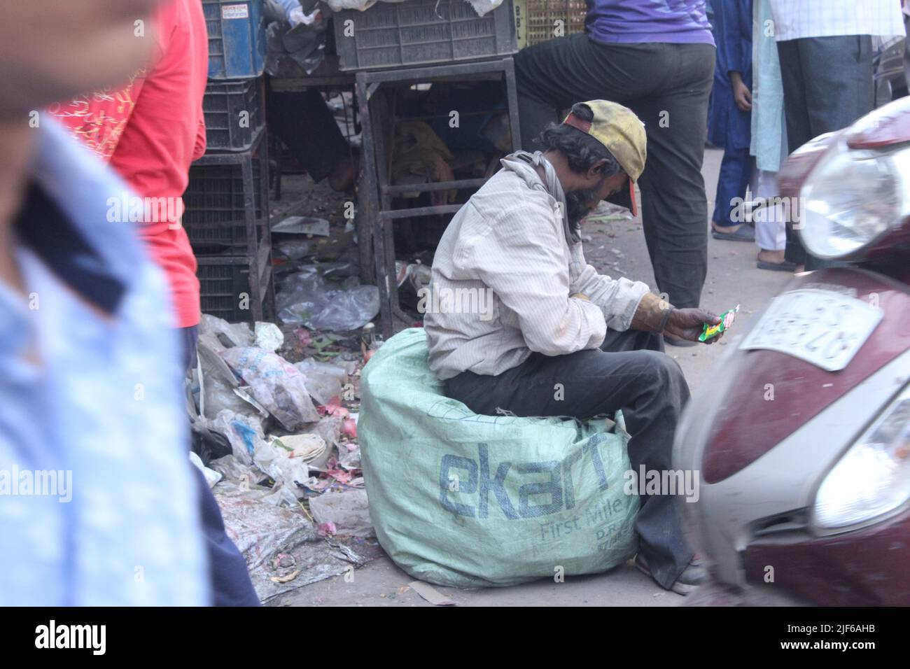 Poor Man seating on heaps of garbage in Old Delhi Stock Photo - Alamy