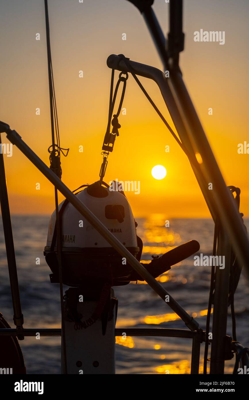 An outboard machine hanging on a sailboat's deck while sunset Stock ...