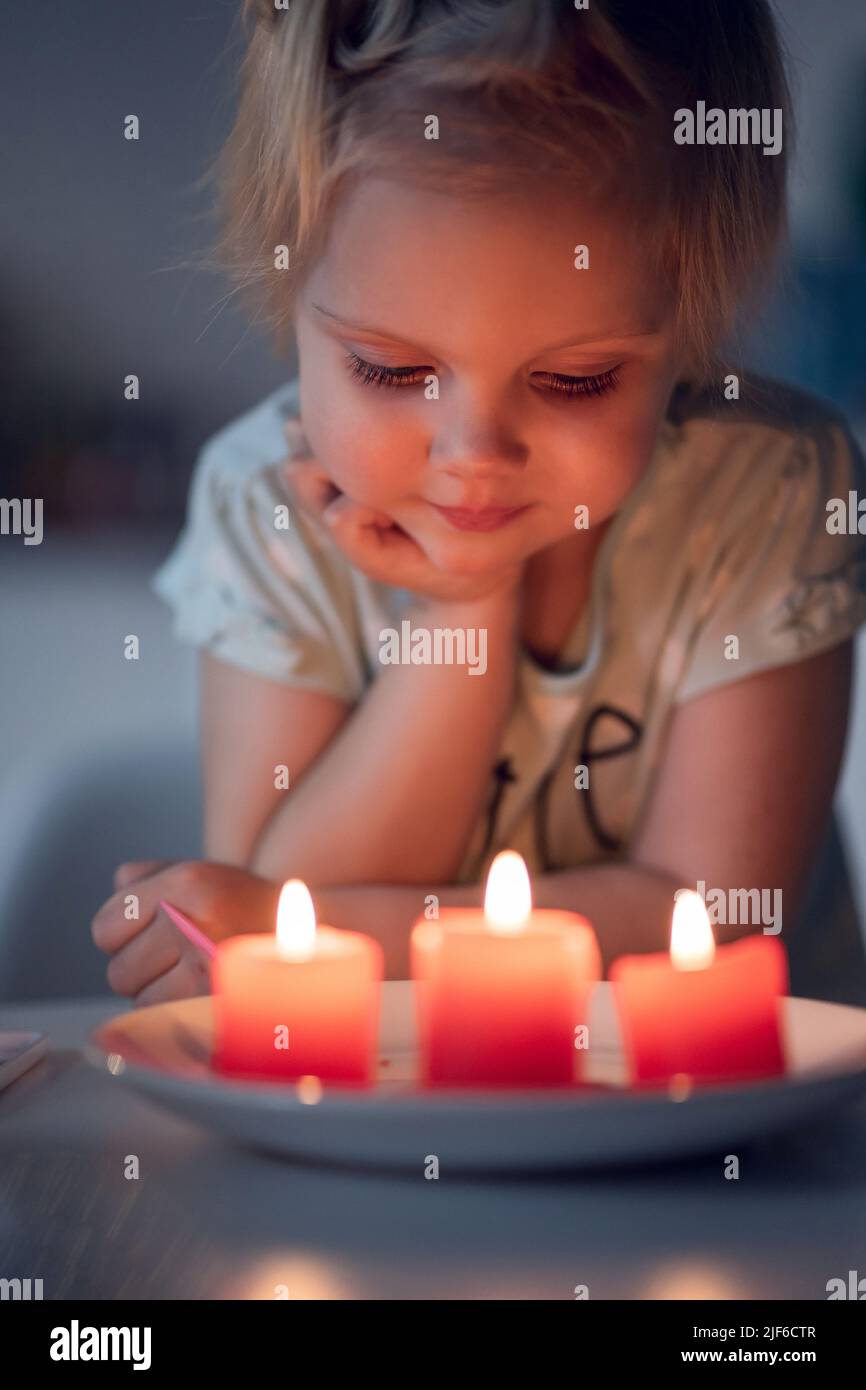 Close-Up Of Girl Holding Illuminated Candle. Cute little Girl above ...
