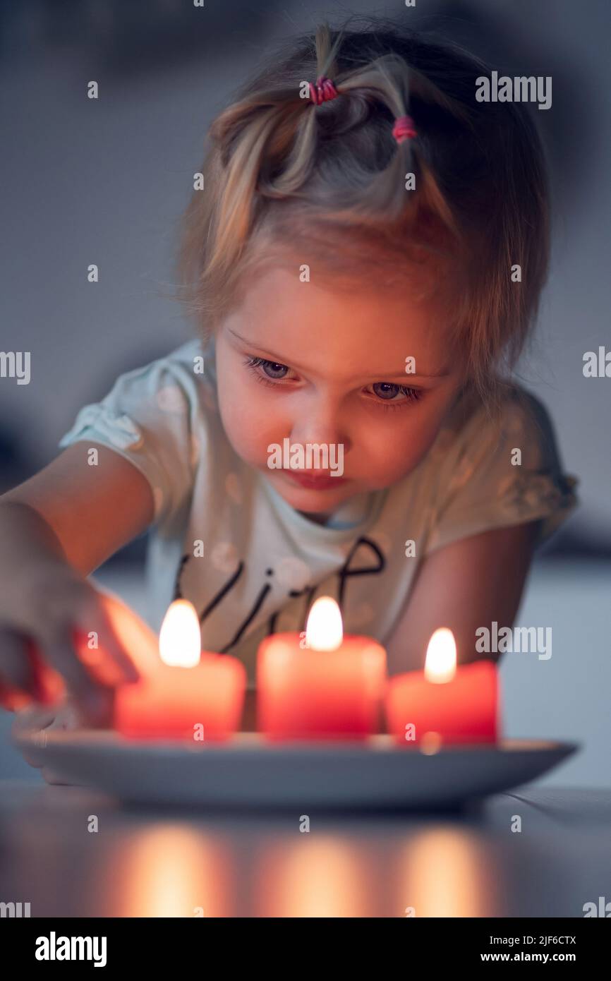 Close-Up Of Girl Holding Illuminated Candle. Cute little Girl above ...