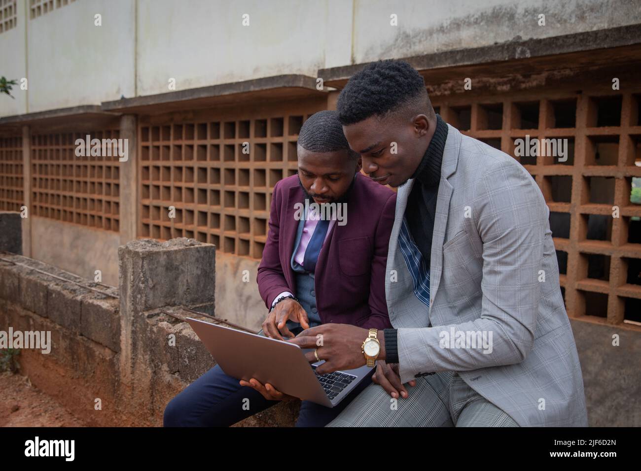 Two colleagues working an a project together look at a laptop screen ...