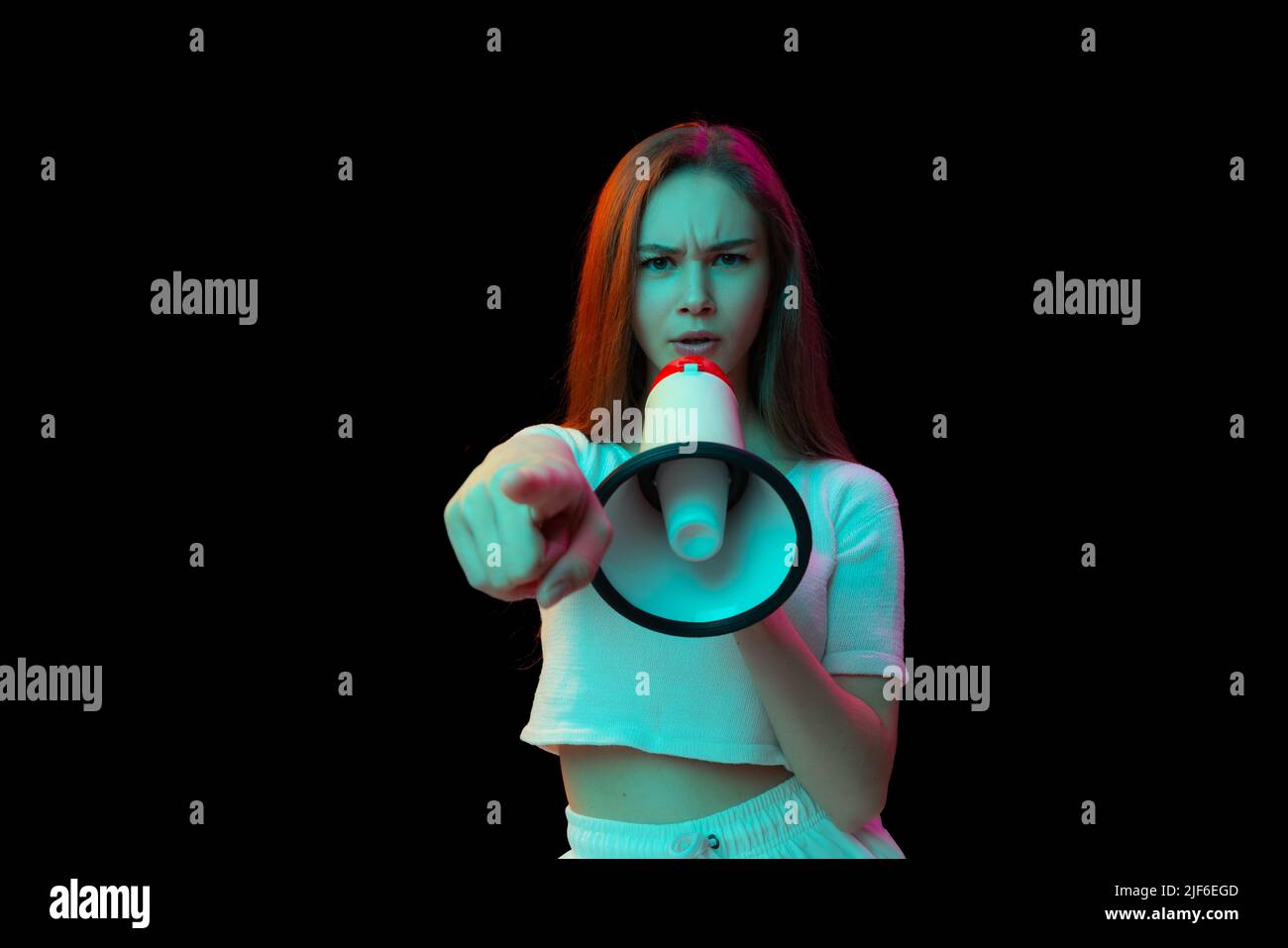 Portrait of young girl shouting in megaphone, posing isolated over ...