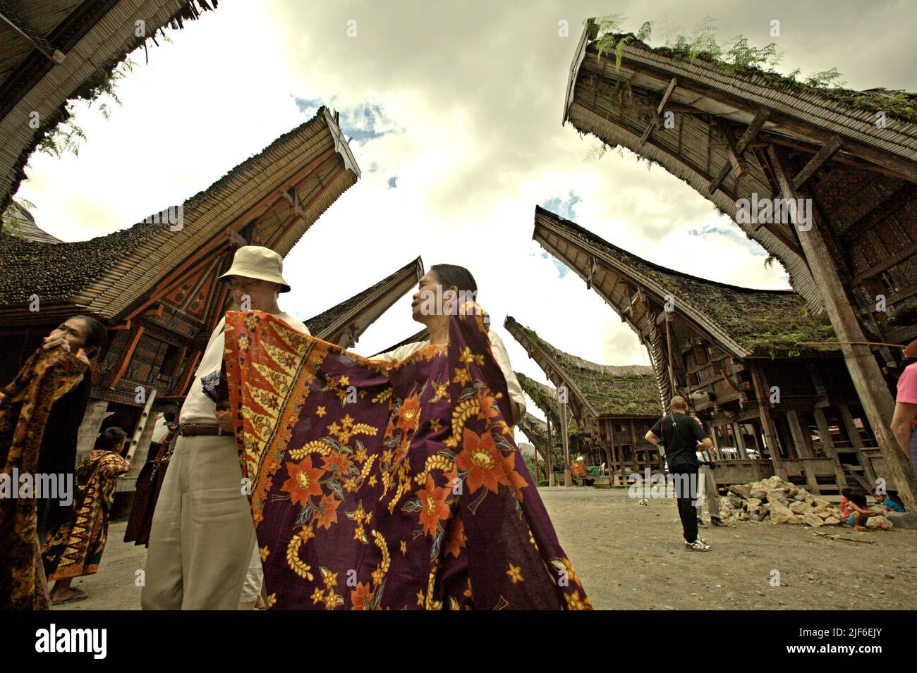 Women villagers selling traditional textiles to tourists in traditional ...