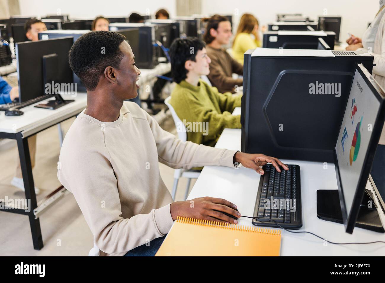Young african student using computer inside college room at school ...
