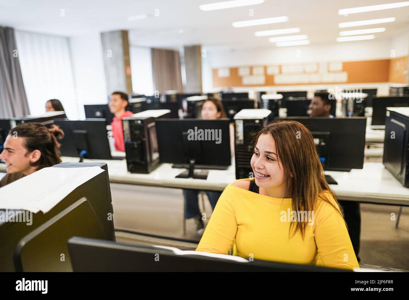 Young students using computers inside technology class at school room ...