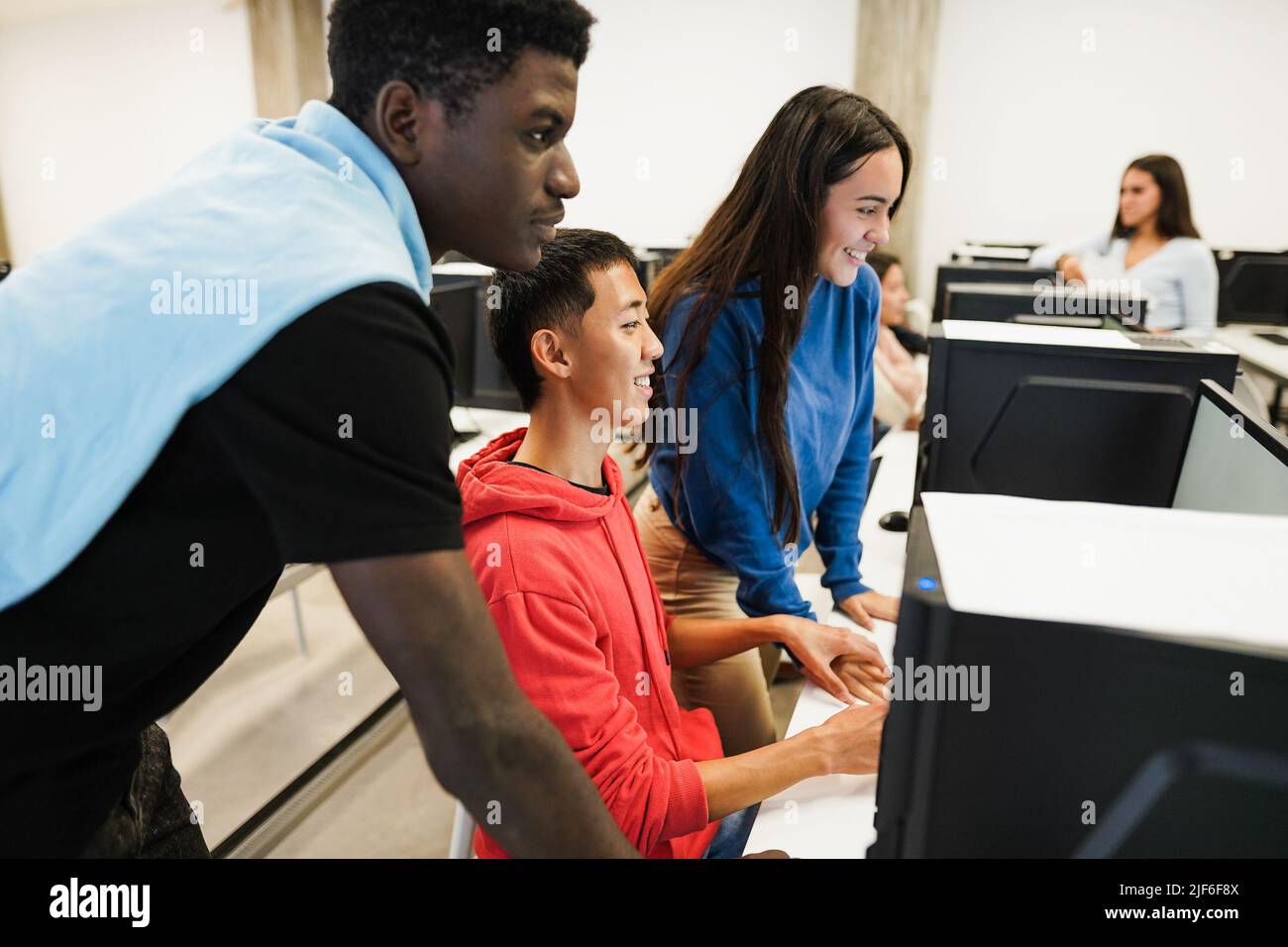 Multiracial students using computers during business class at school ...