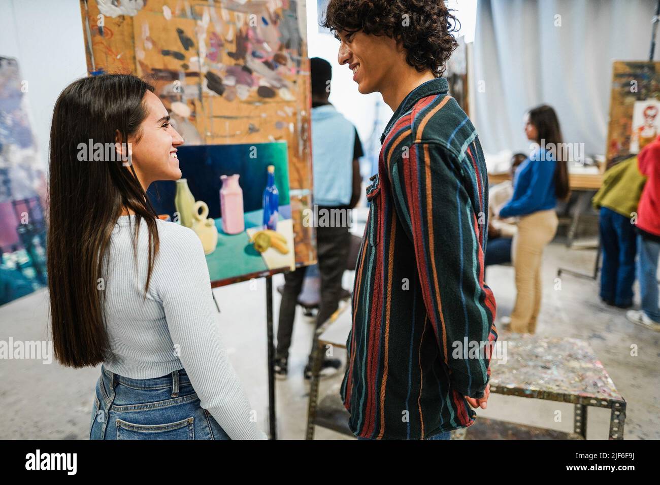 Young students painting inside art room class at university - Focus on ...