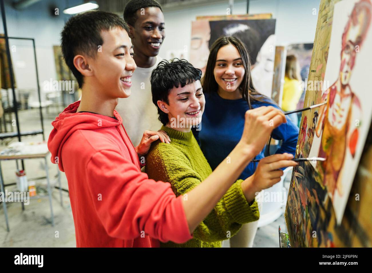 Multiracial students painting inside art room class at university ...