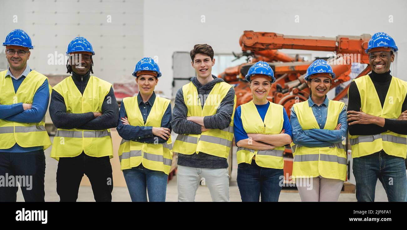 Multiracial engineers working inside robotic factory - Focus on center ...