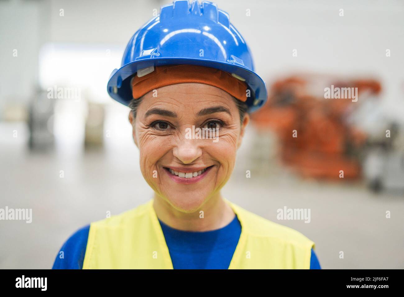 Senior engineer woman working inside robotic factory - Focus on eyes ...