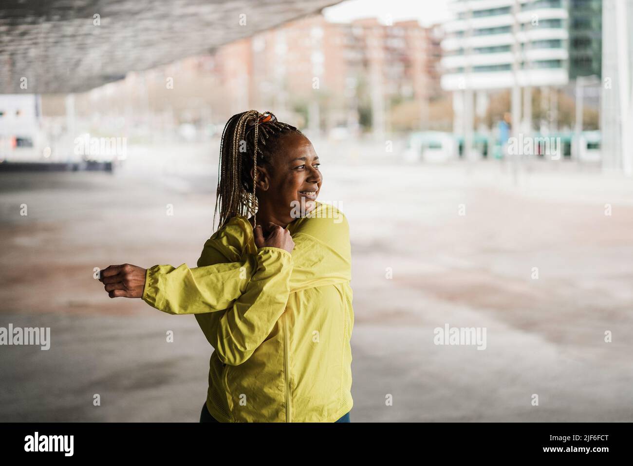 Senior african woman stretching during workout routine outdoor - Focus ...