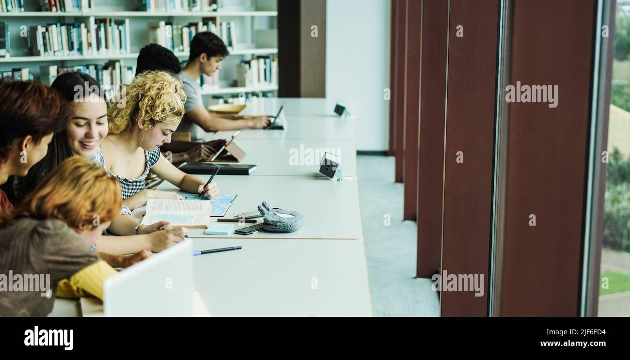Young multiethnic group of students studying inside university library ...
