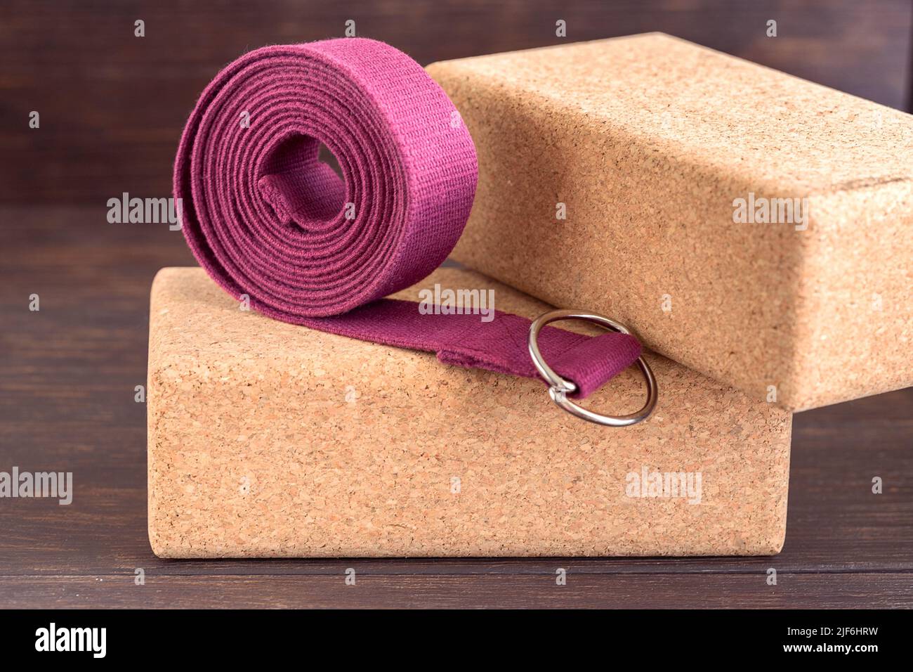 Two cork blocks and violet yoga strap for doing yoga on wooden floor ...