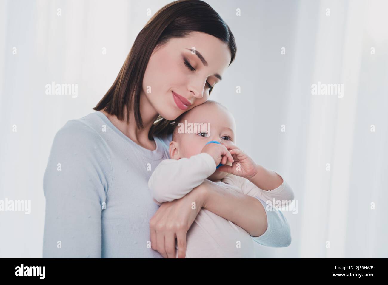 Portrait of peaceful girl closed eyes hands hold hug adorable kid enjoy ...