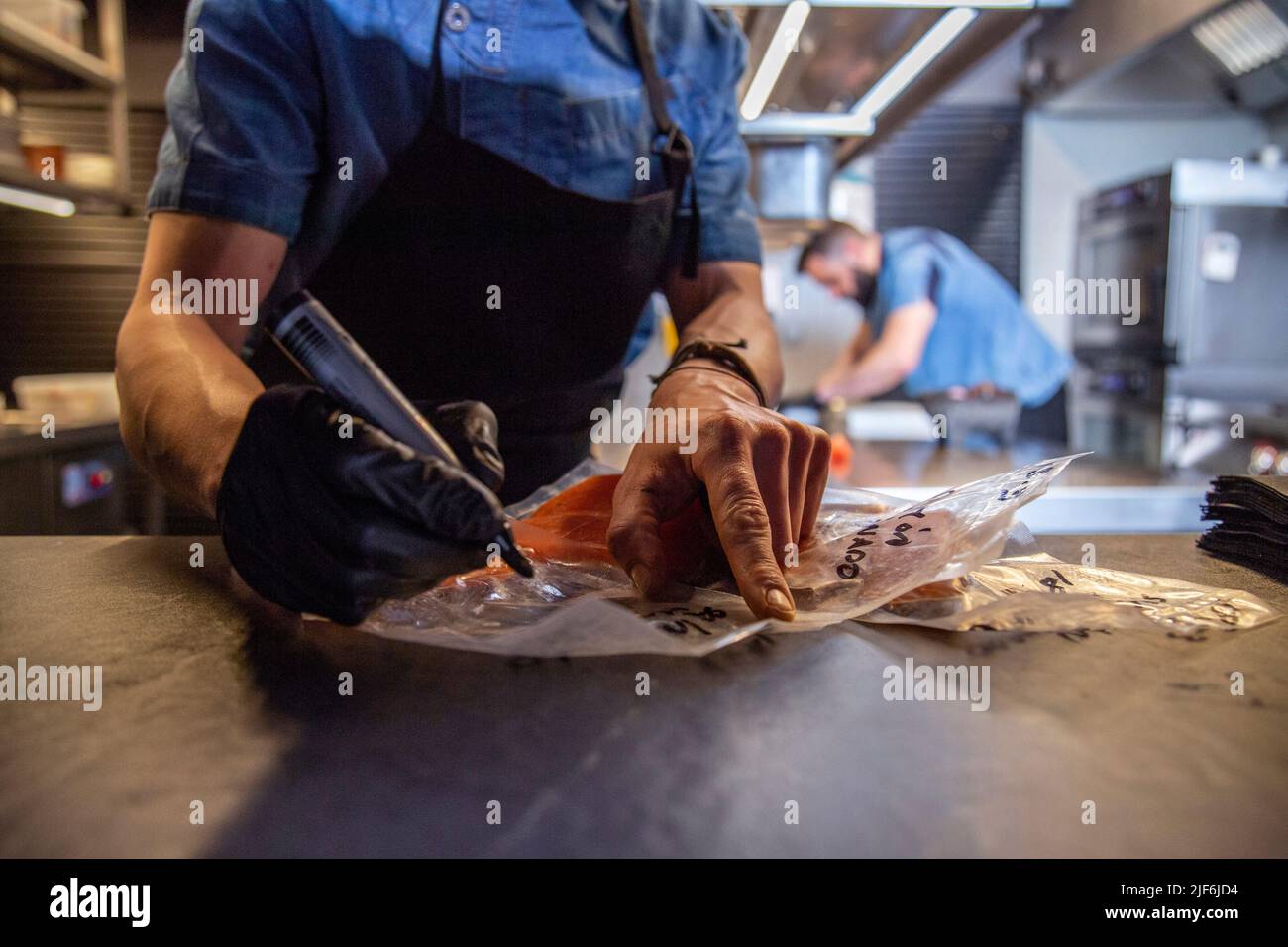 Male chef writing with marker on baking paper while cooking food in ...