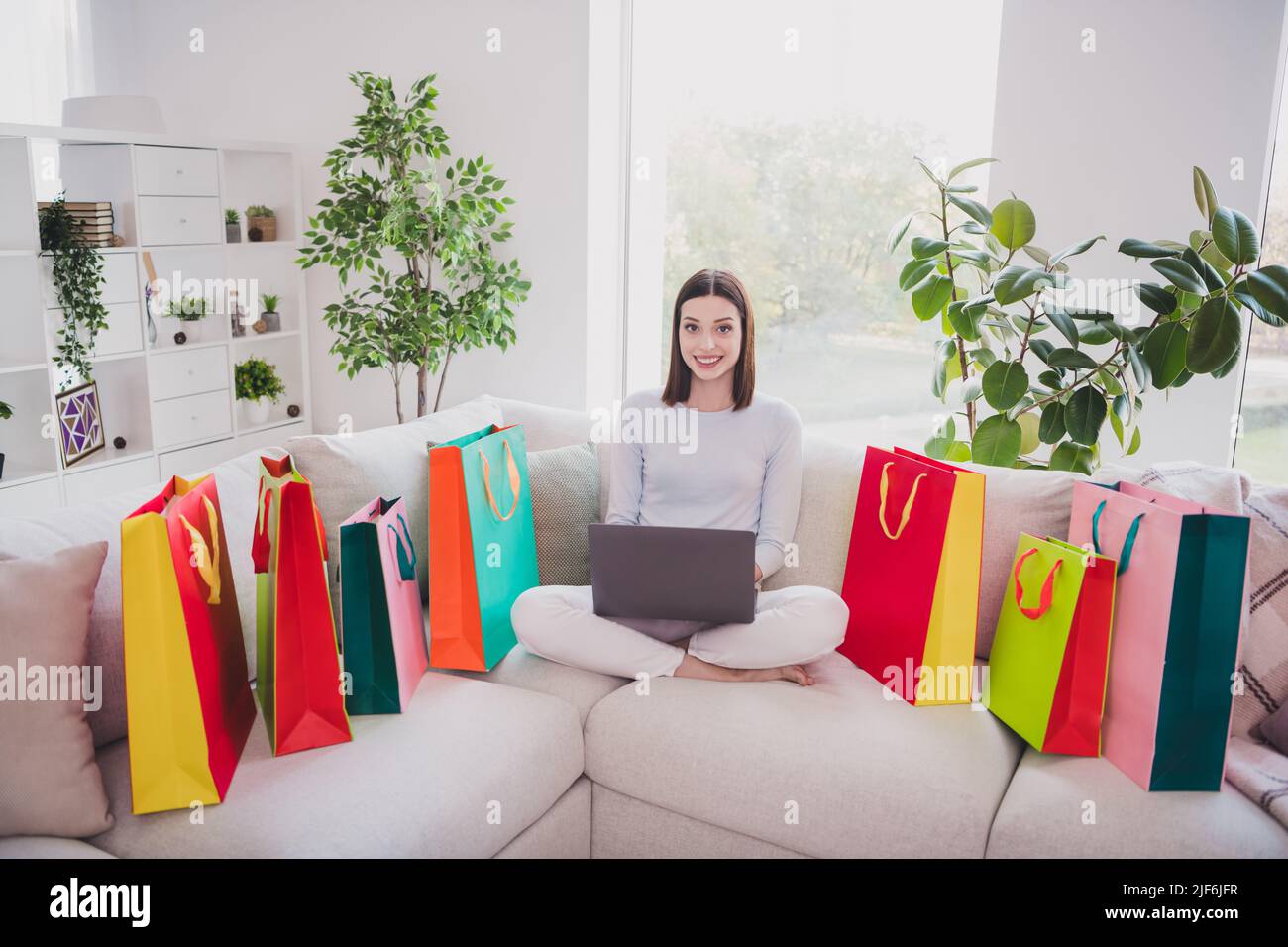 Full body portrait of pretty girl sit sofa use wireless netbook receive ...