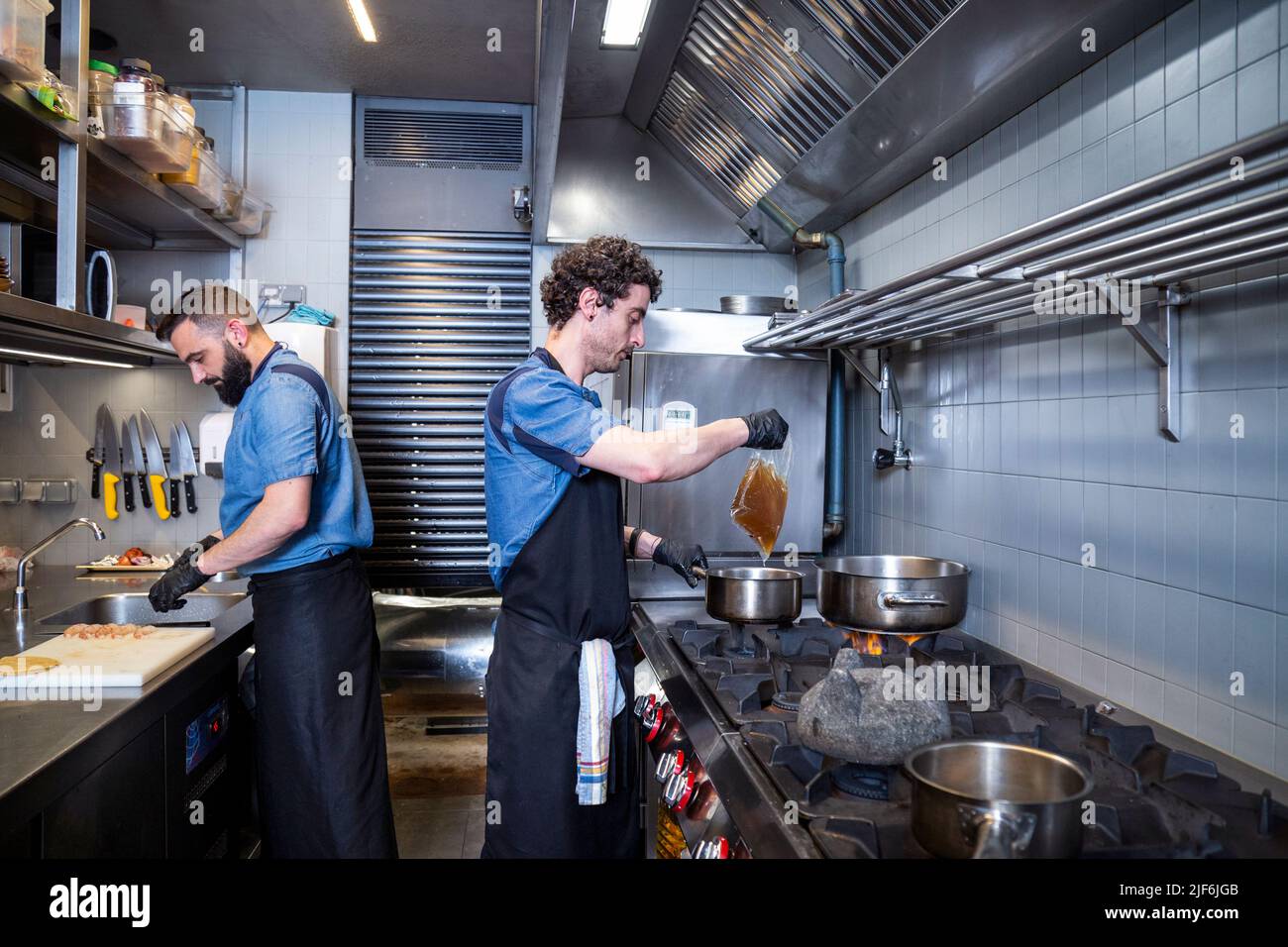 Side view of male chefs preparing food in commercial kitchen Stock ...