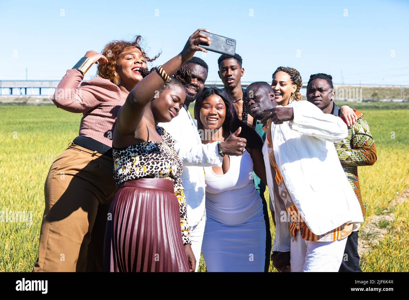 Happy African friends in stylish clothes smiling and taking selfie via ...