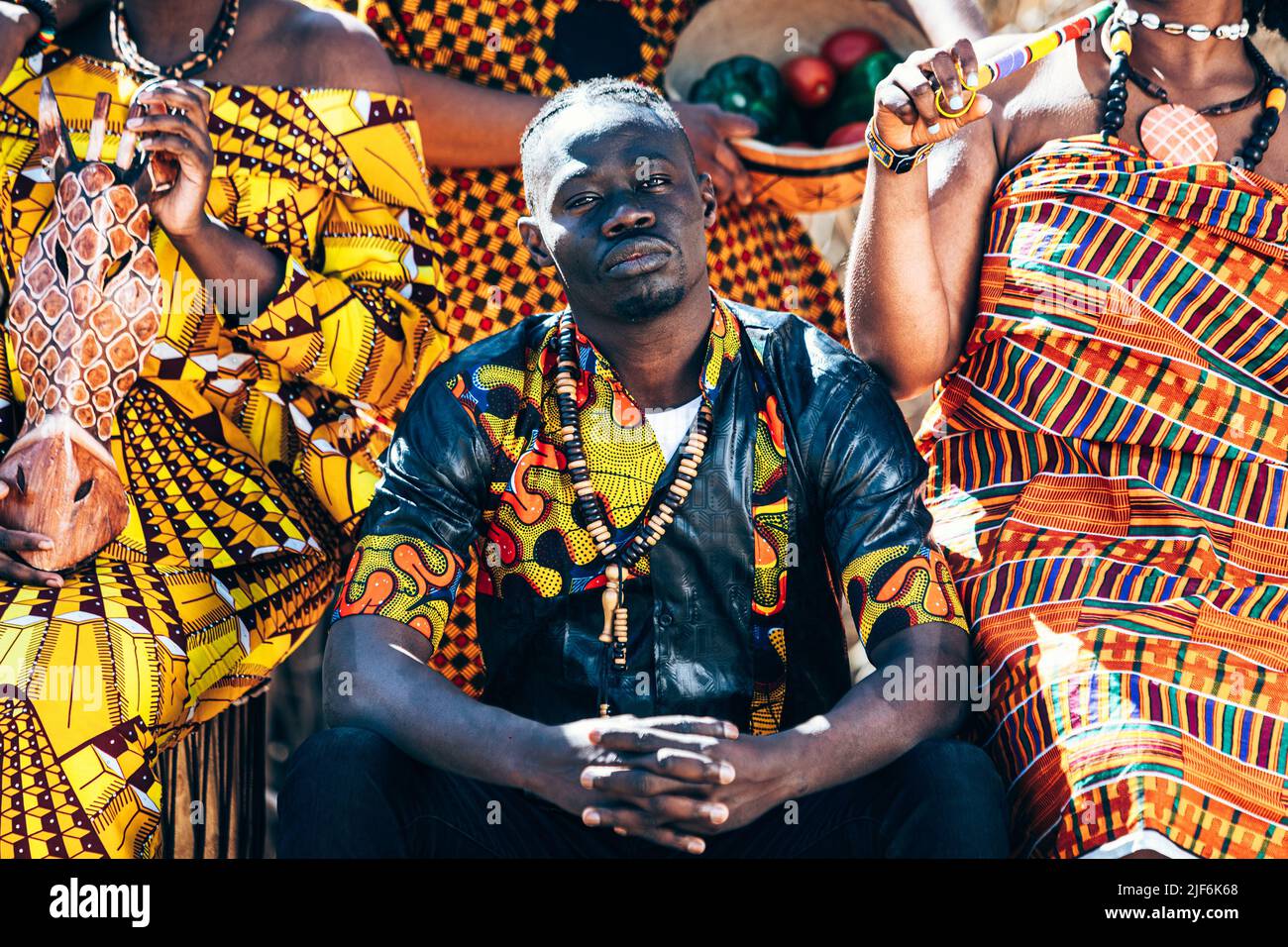 Serious black man in traditional African clothes clasping hands and ...