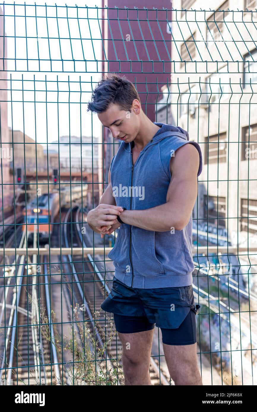 Sport Caucasian man looking smart watch at modern track runner ...