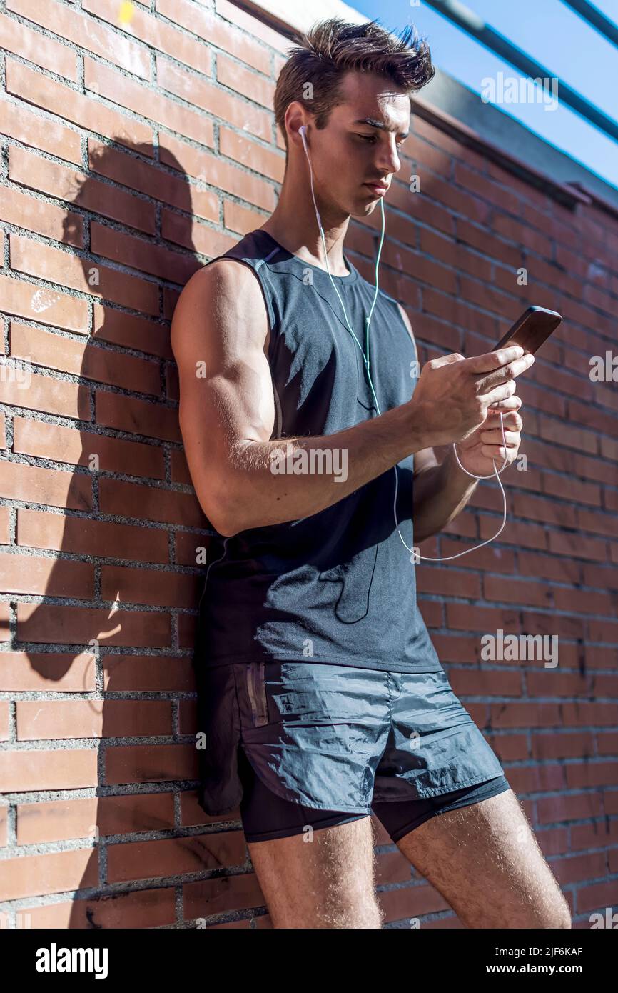 Shot of muscular young man relaxing after workout. Male runner man ...