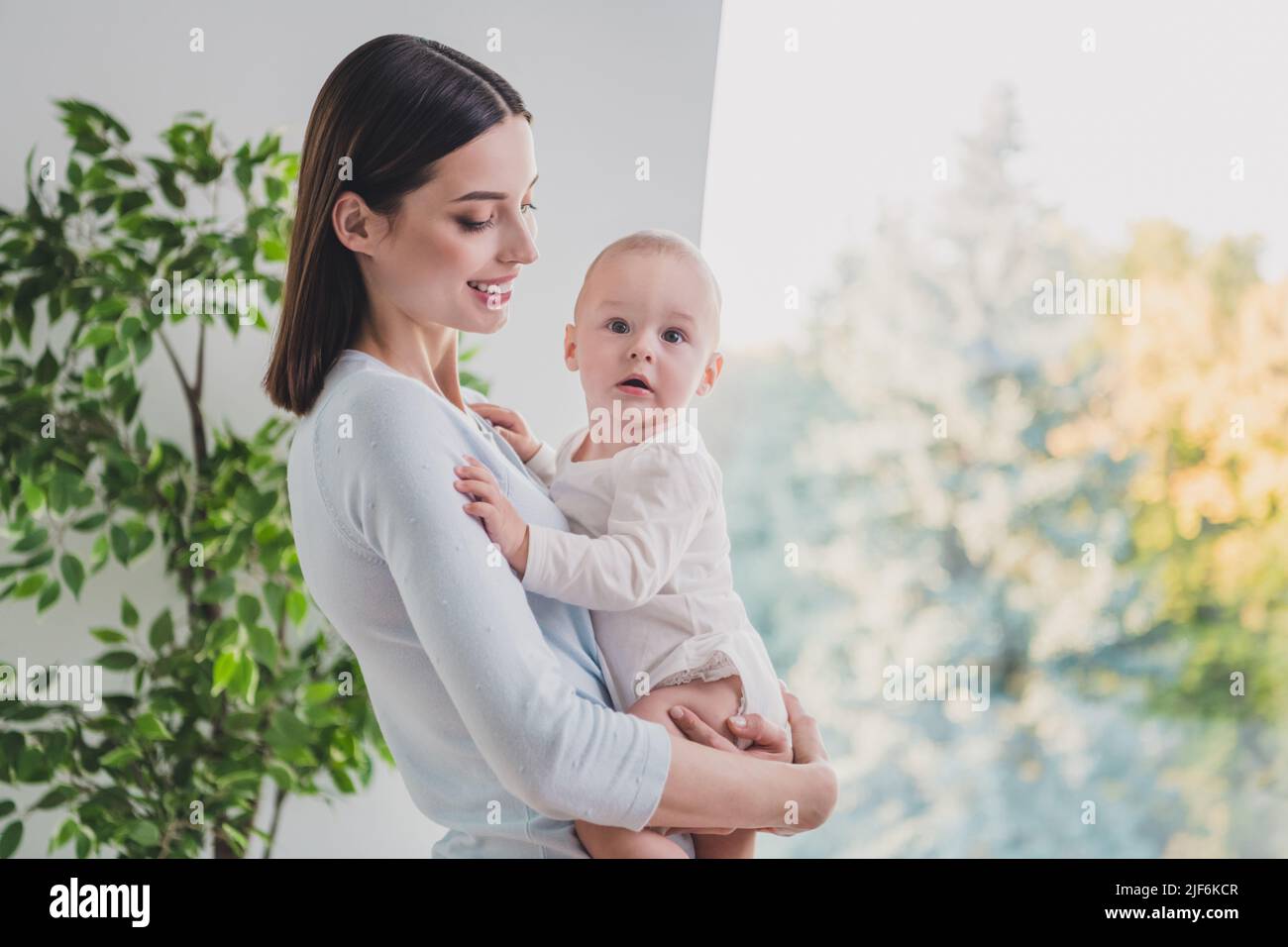 Profile photo of pretty cheerful girl arms hold cuddle cute toddler ...