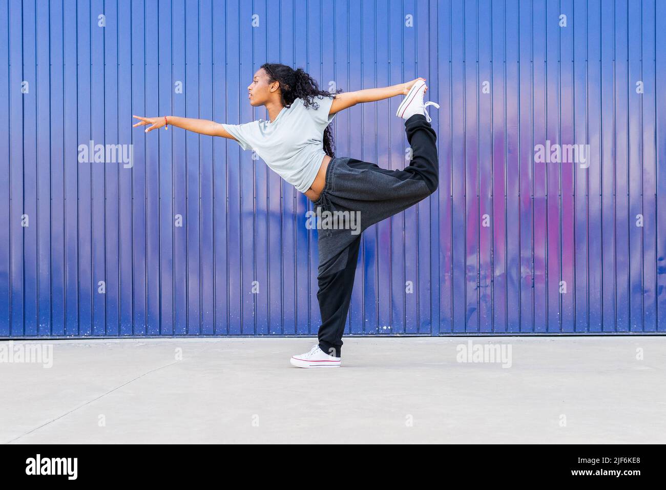 Full body side view of active African American female dancer standing ...