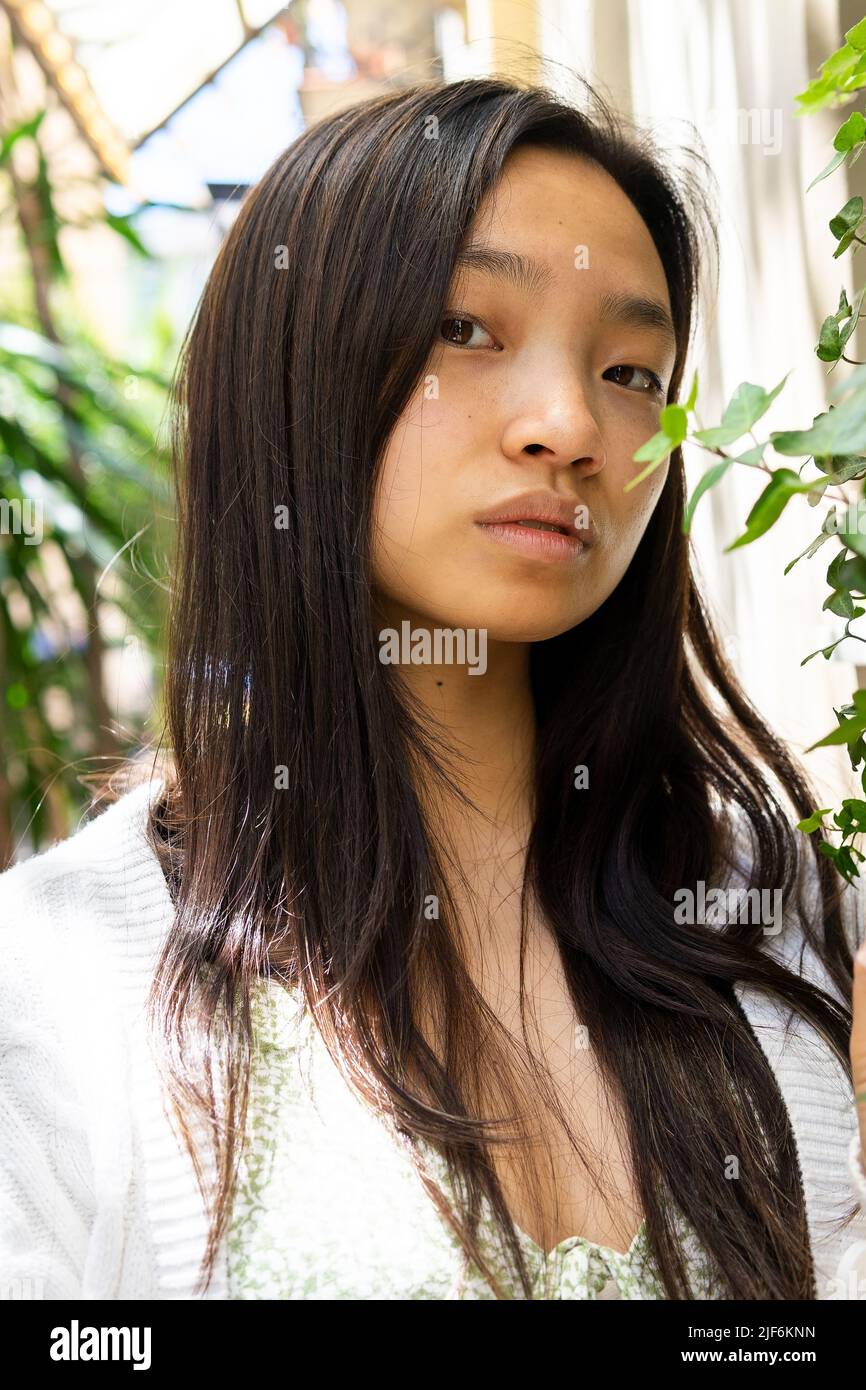 Side view of positive female with ponytail looking out window while ...