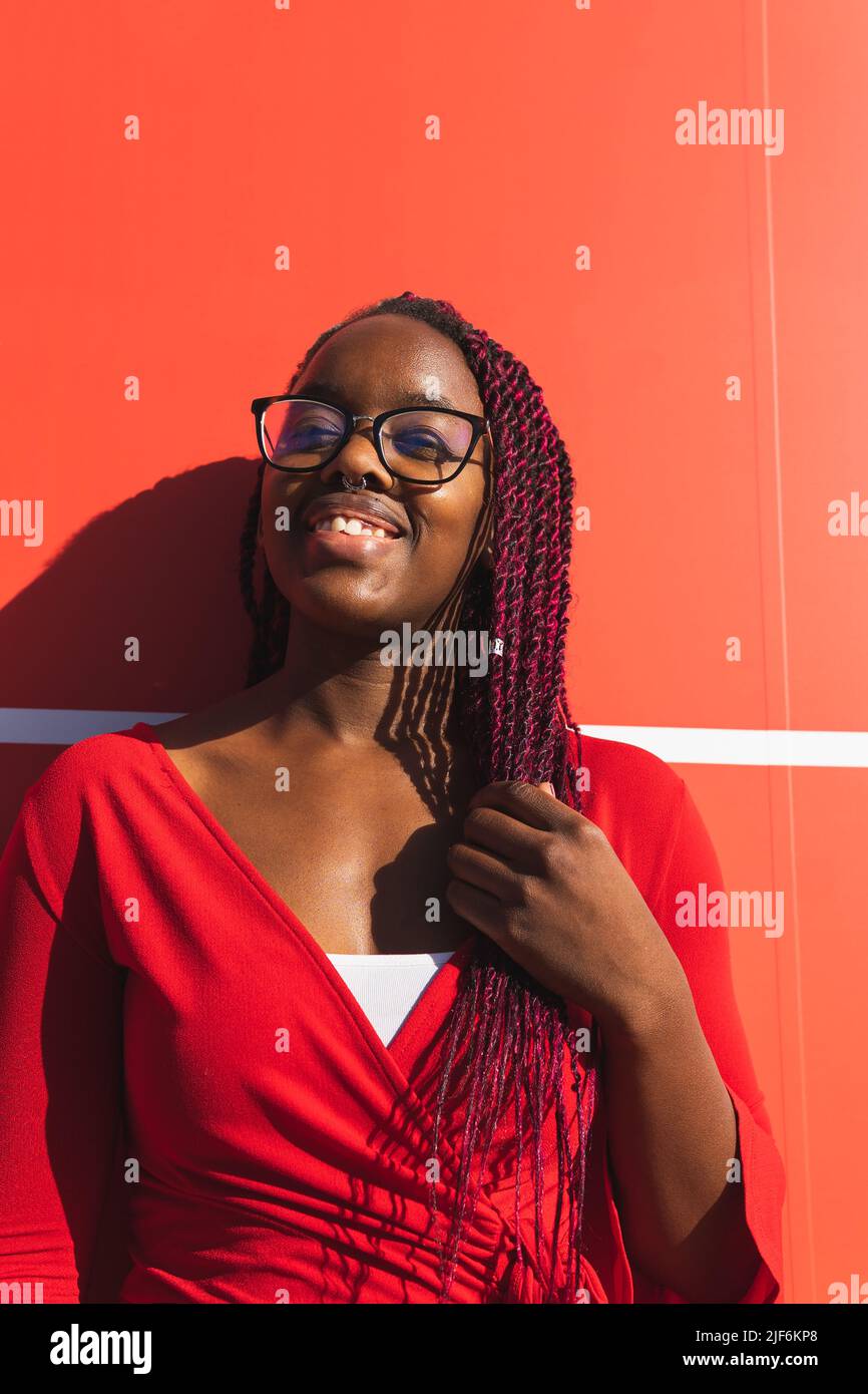 Cheerful young African American female in trendy outfit and glasses ...