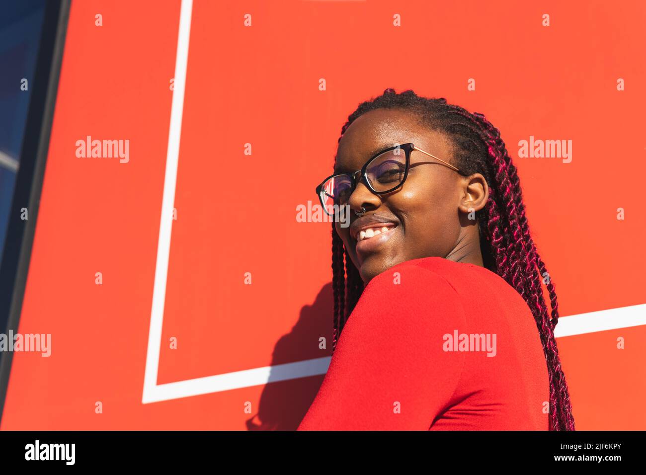 Side view of young African American female in trendy outfit and glasses ...