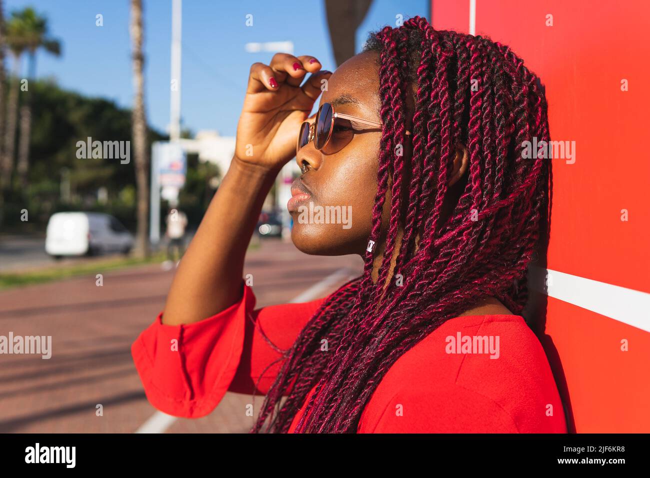 Side view of young African American female in trendy outfit and glasses ...