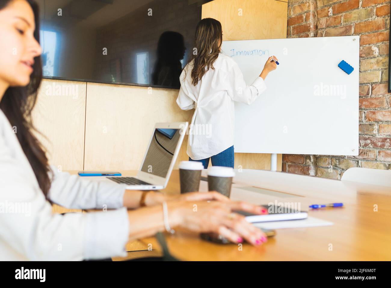 Female entrepreneur in smart casual clothes writing down data on ...